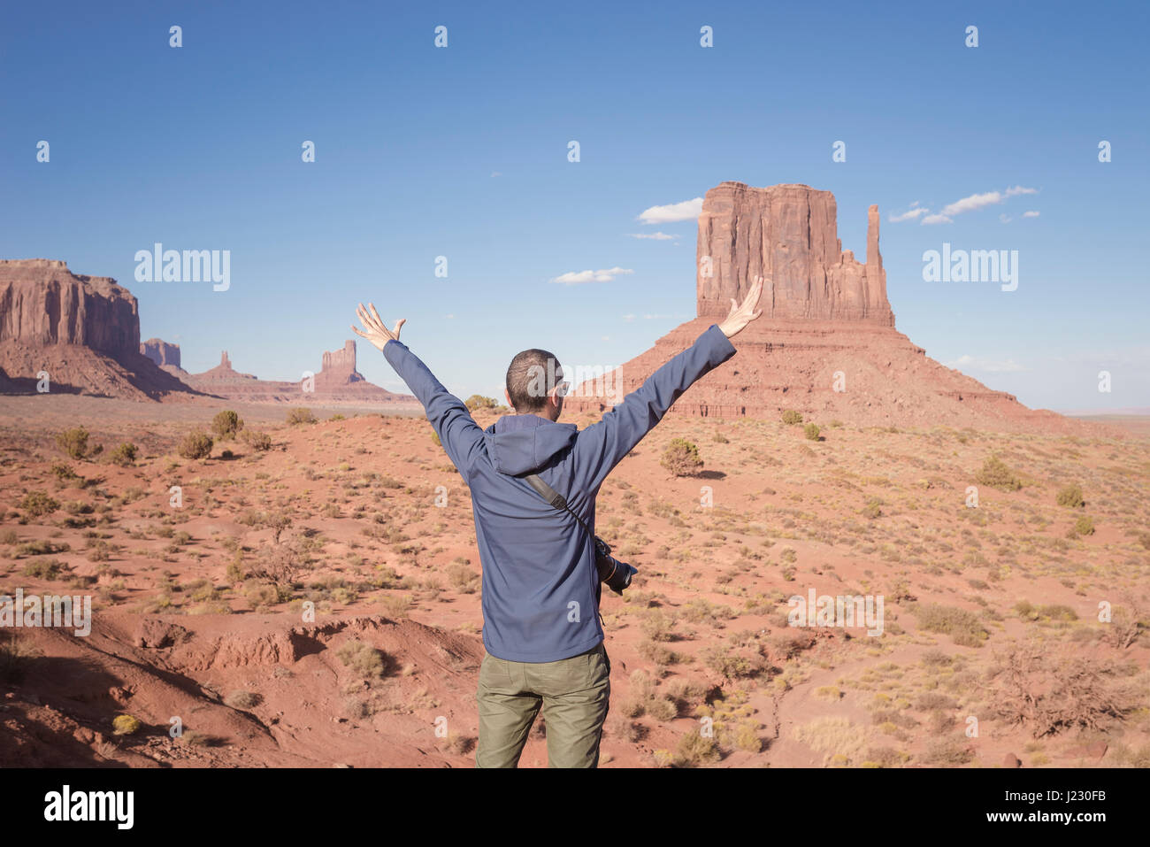 Back view man raised arms looking monument valley hi-res stock ...