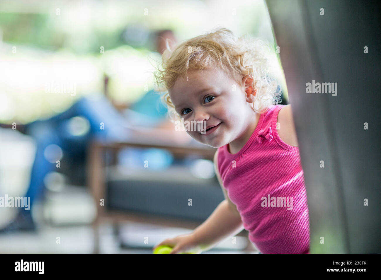 Baby girl smiling from corner Stock Photo - Alamy
