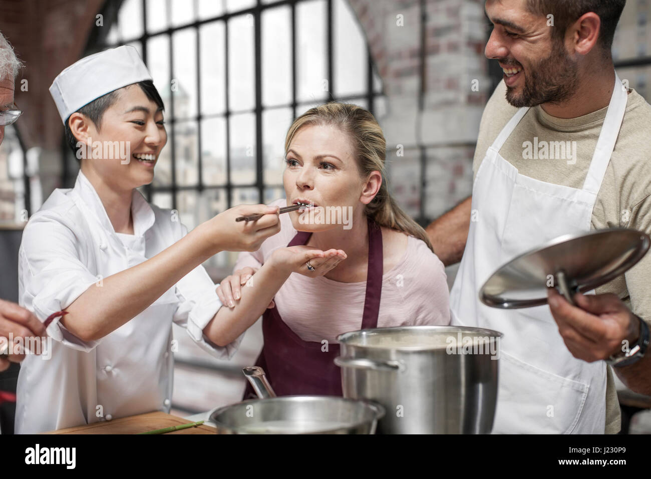 Female student tasting from pot in cooking class Stock Photo - Alamy