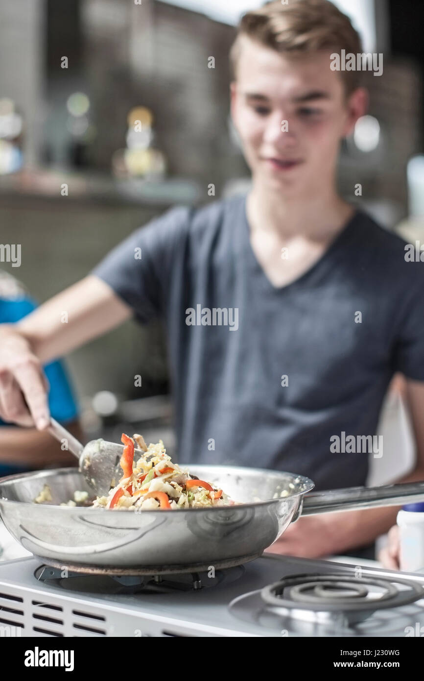 Teenager cooking on stove Stock Photo - Alamy