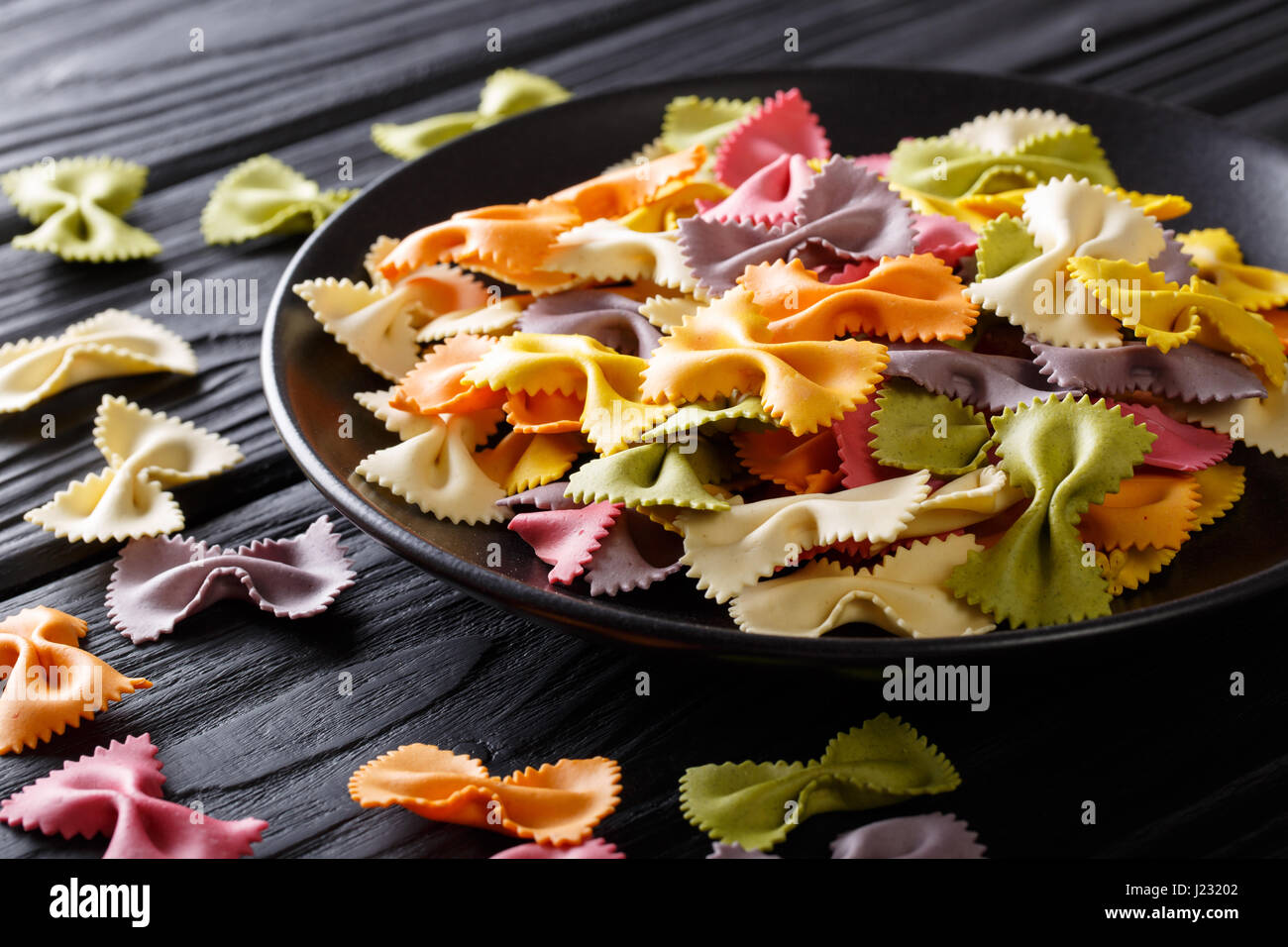 Italian raw multicolored farfalle pasta close-up on the table ...
