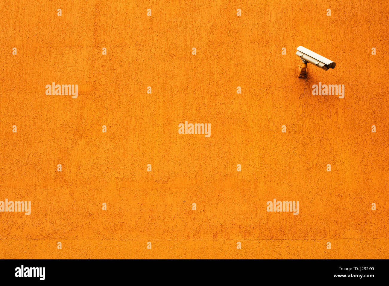 CCTV camera on orange building facade as copy space Stock Photo - Alamy