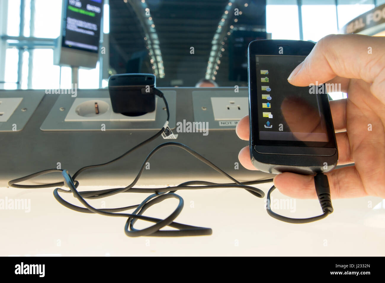 Using a mobile phone while charging the battery at the airport. Phone ...