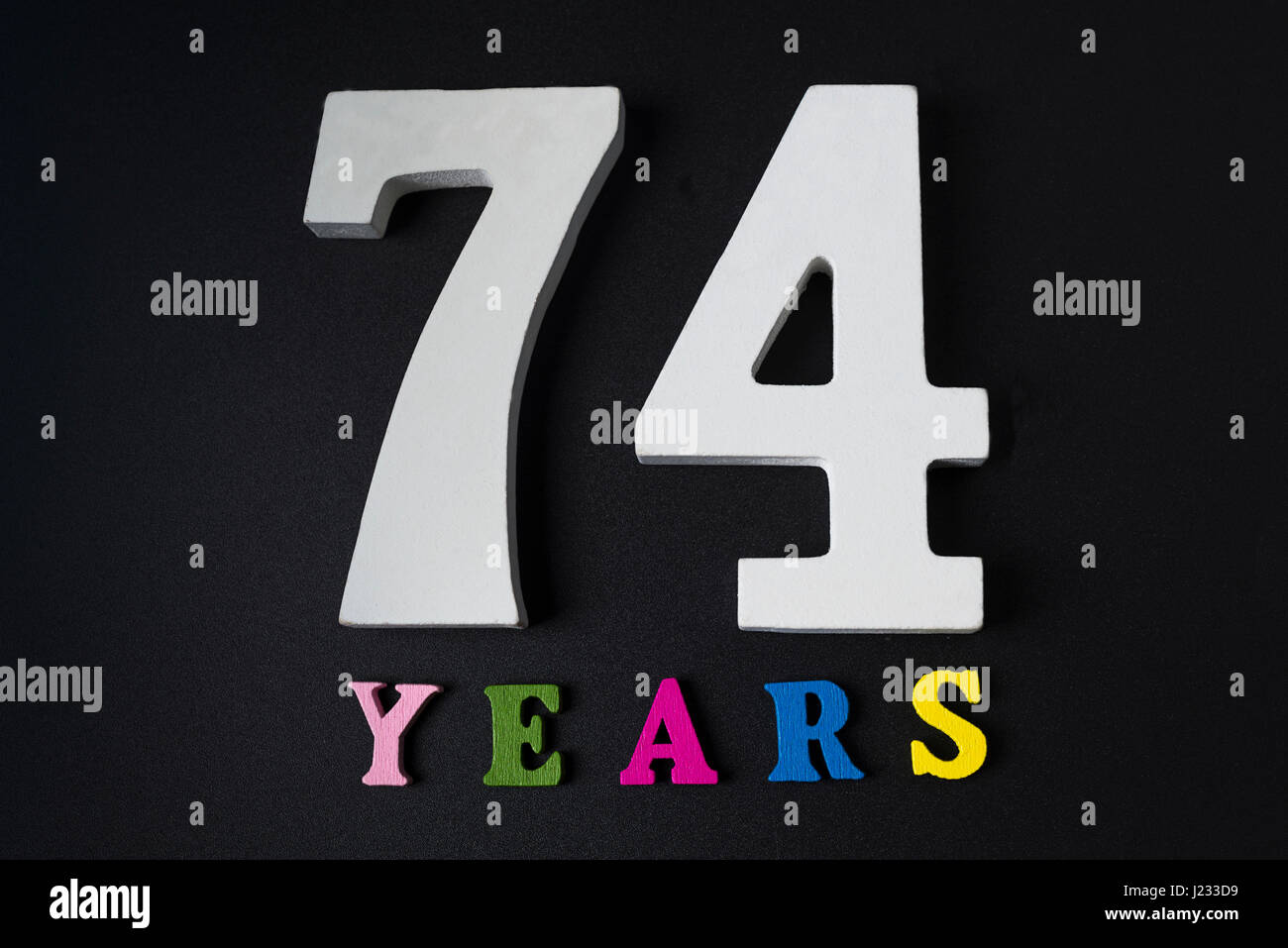 Letters and numbers seventy-four years on a black isolated background ...