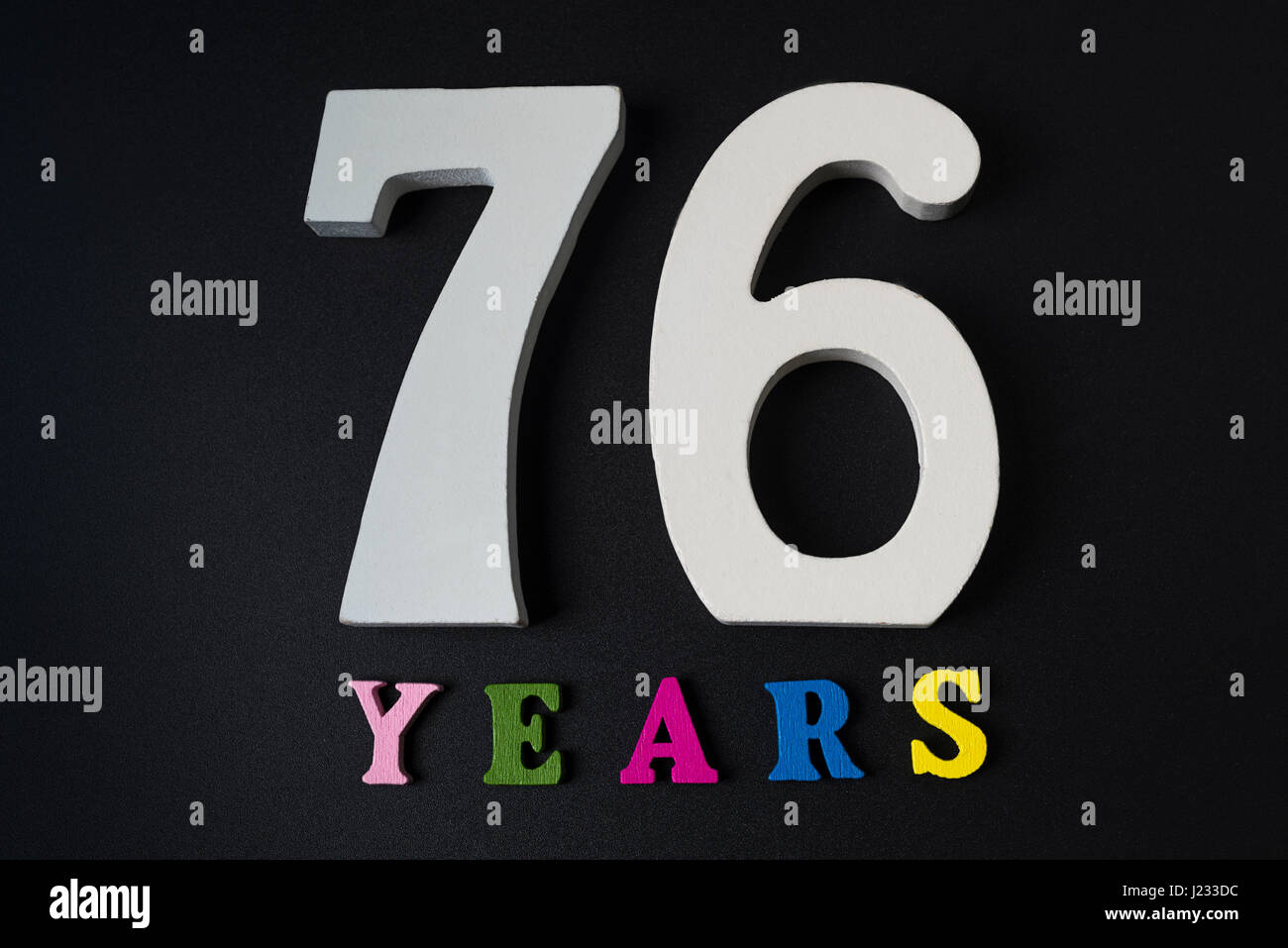 Letters and numbers seventy-six years on a black isolated background ...