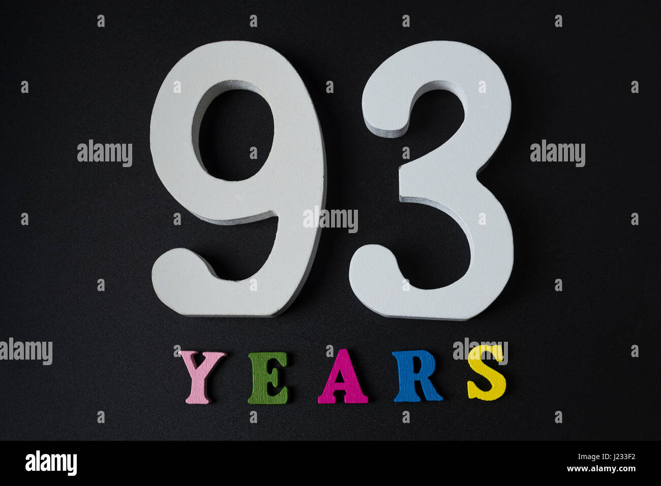 Letters and numbers ninety-three years on black isolated background ...