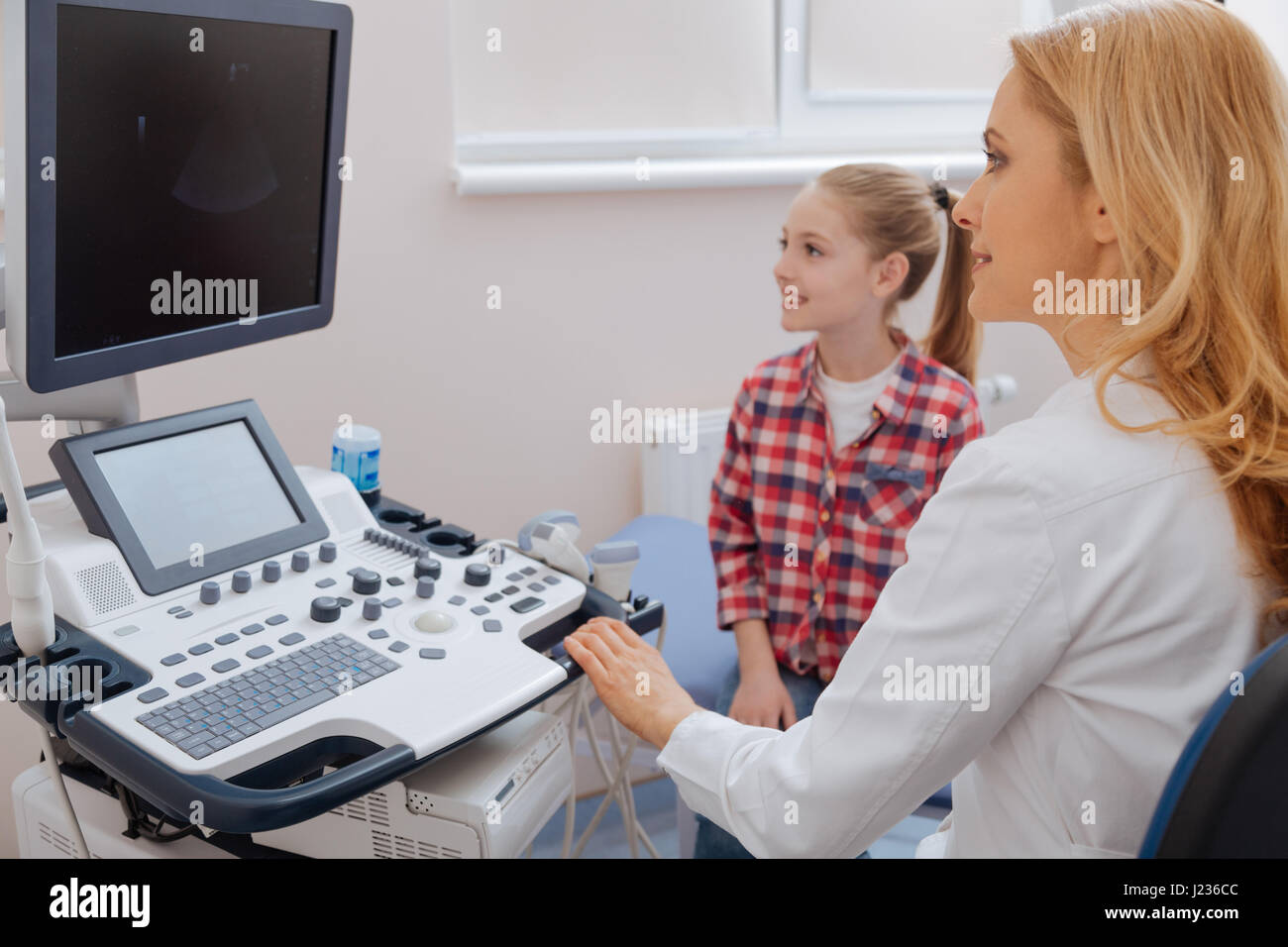 Glad practitioner teaching girl professional aspects in the sonography ...