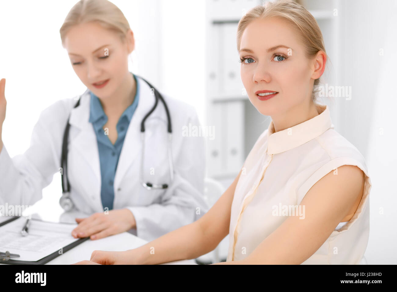 Doctor and patient sitting at the desk Stock Photo - Alamy