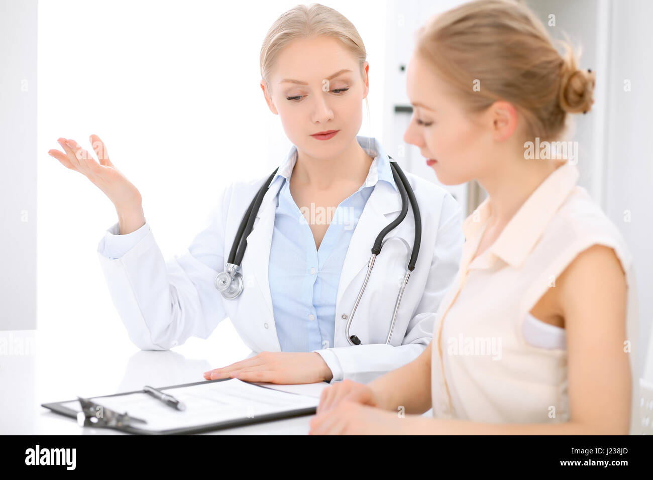 Doctor and patient sitting at the desk Stock Photo - Alamy