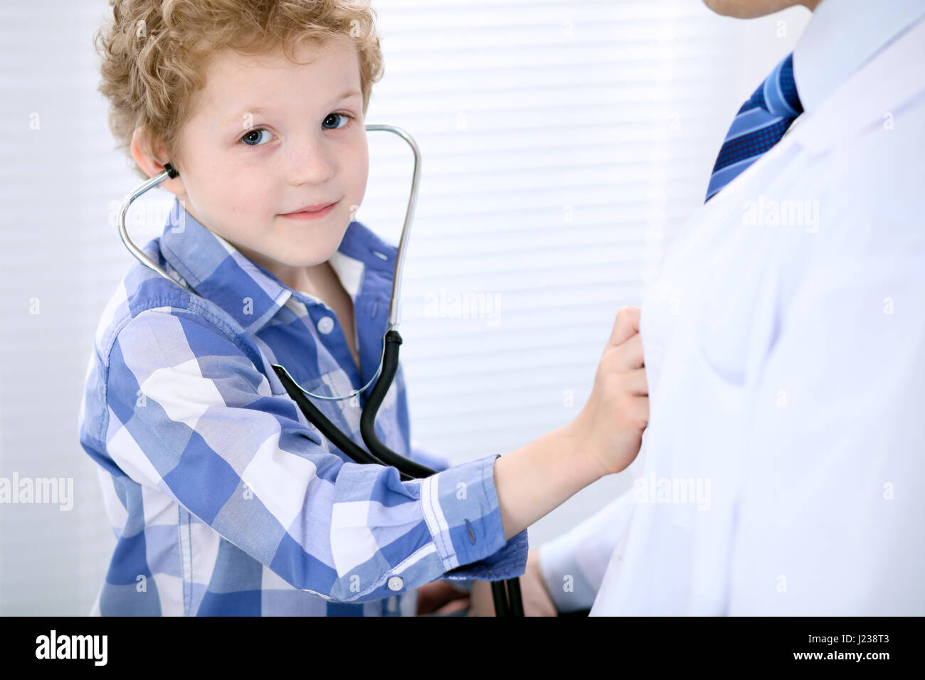 Child patient examining his doctor by stethoscope Stock Photo - Alamy