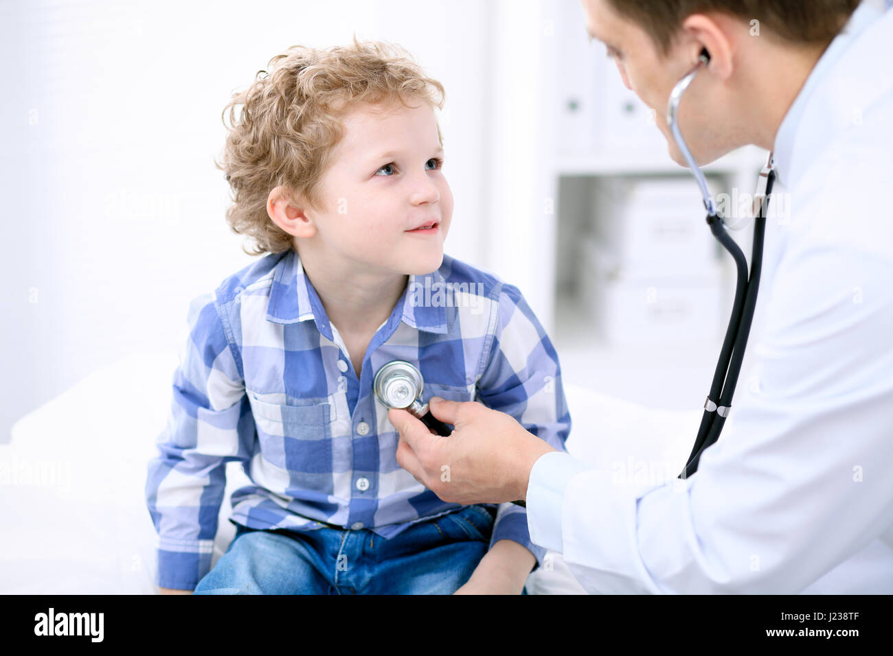 Doctor examining a child patient by stethoscope Stock Photo - Alamy