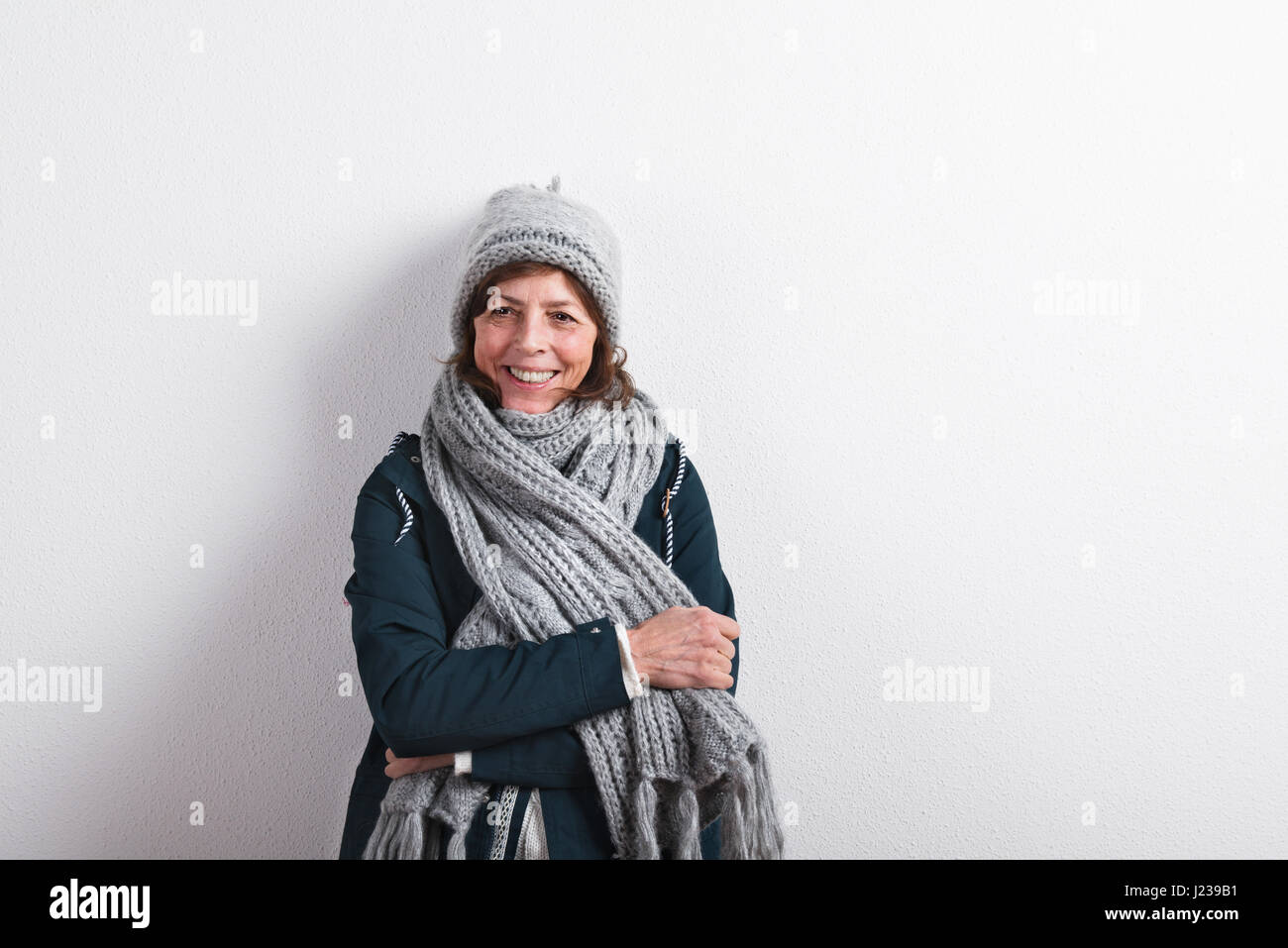 Senior woman in woolen scarf and hat, studio shot Stock Photo - Alamy