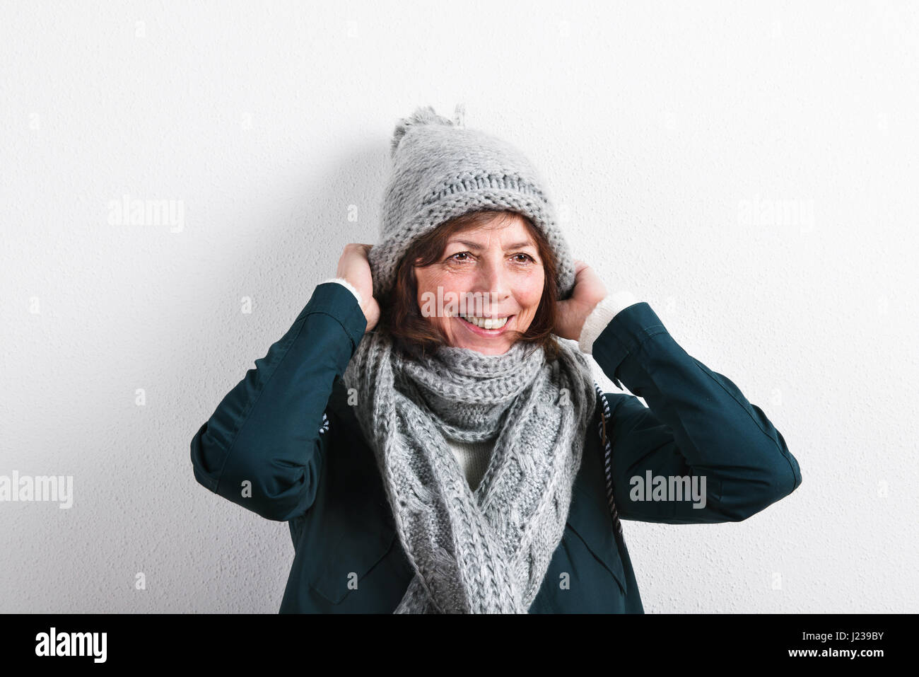Senior woman in woolen scarf and hat, studio shot Stock Photo - Alamy