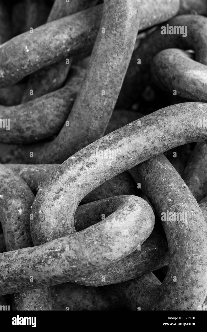 A close up image of thick, heavy metal chains tangled up together and ...