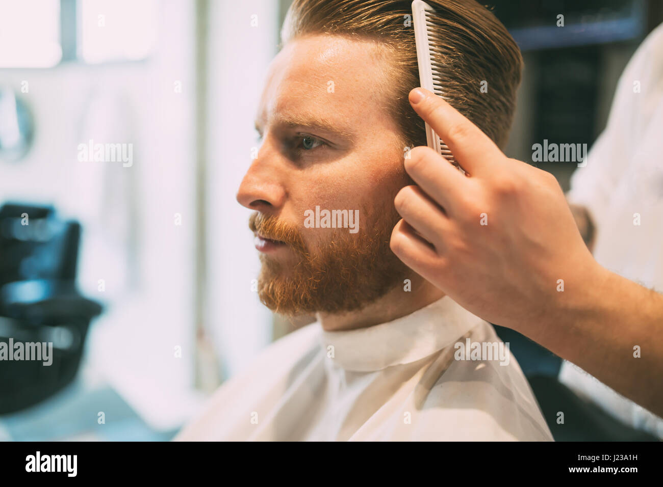 Combing of hair and styling in barber shop Stock Photo - Alamy