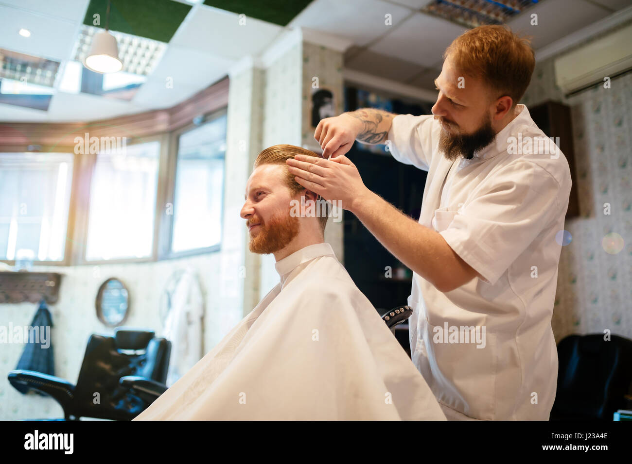 Male receiving hair beard treatment in barber shop Stock Photo - Alamy
