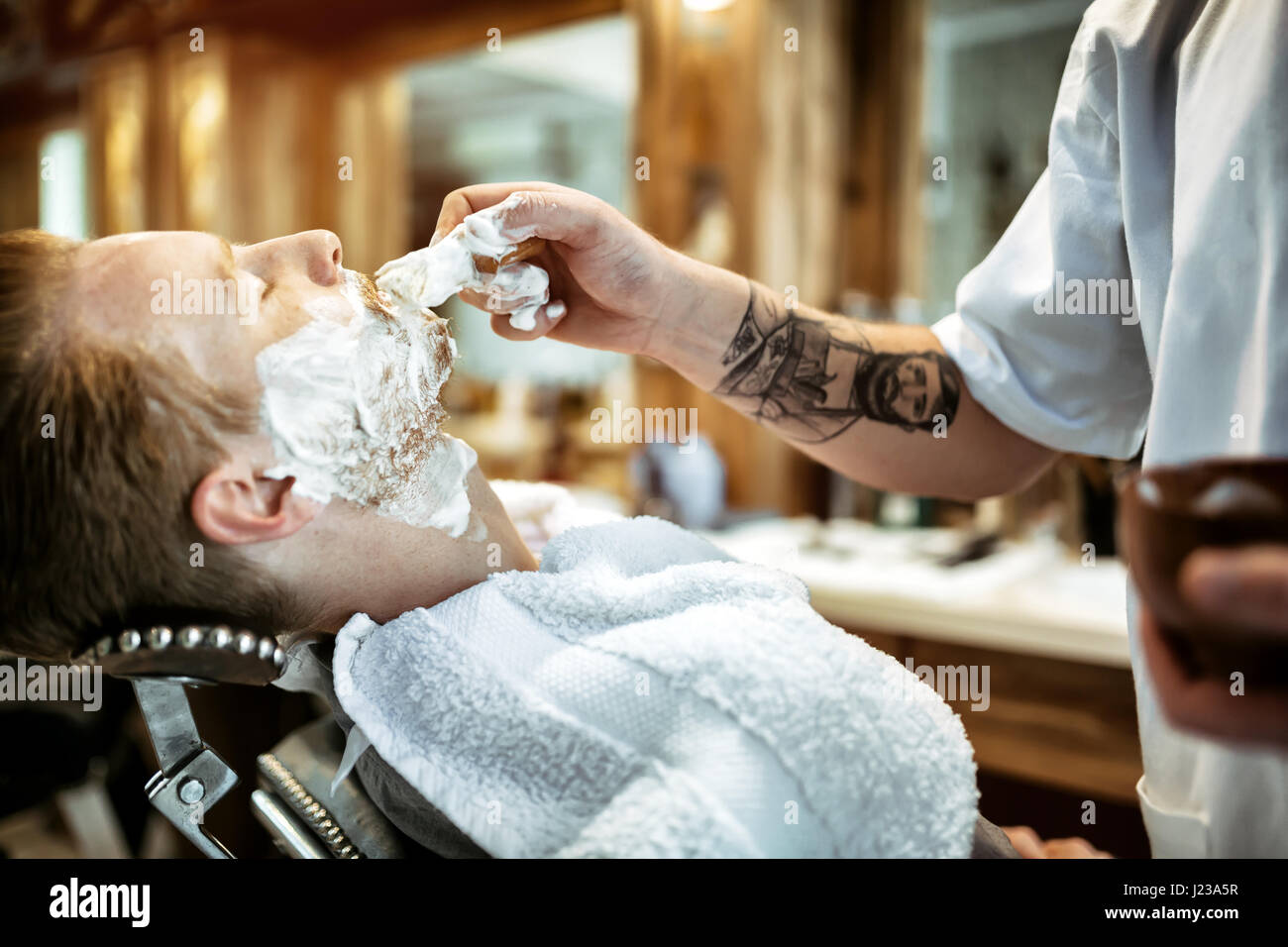 Male receiving hair beard treatment in barber shop Stock Photo - Alamy