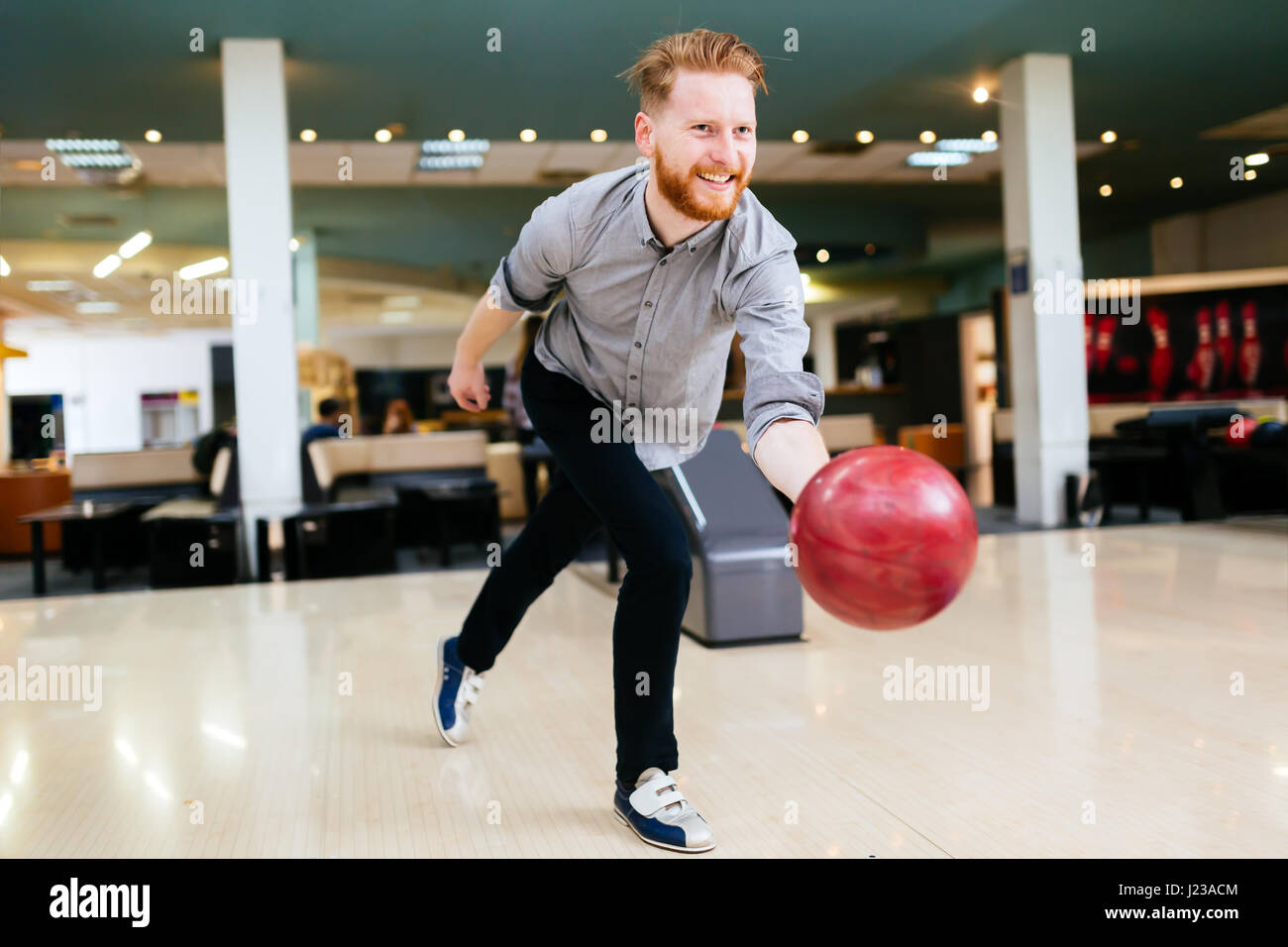 Handsome man bowling in club and throwing ball Stock Photo - Alamy