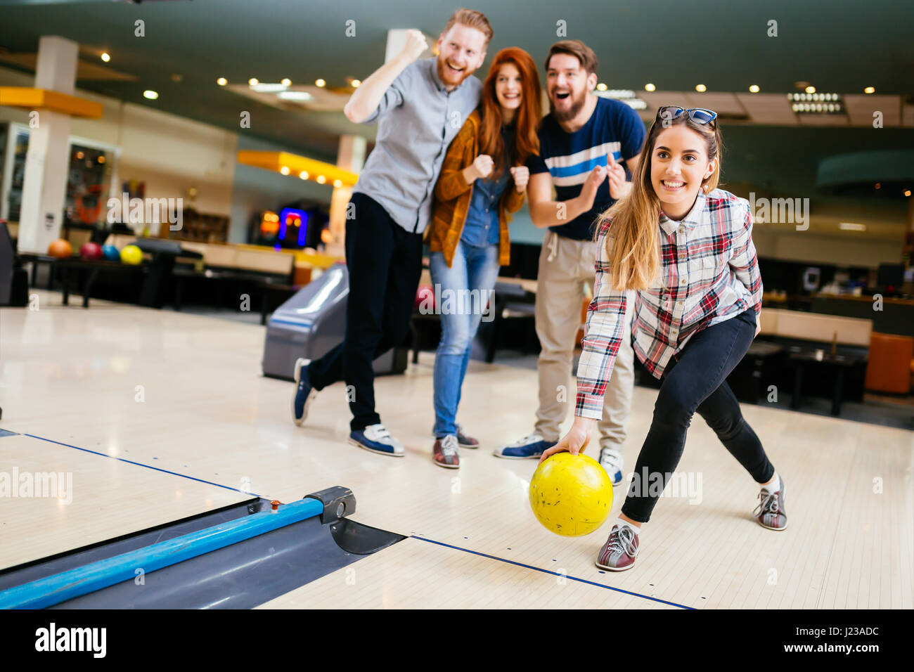 Friends enjoying recreational bowling at club Stock Photo - Alamy