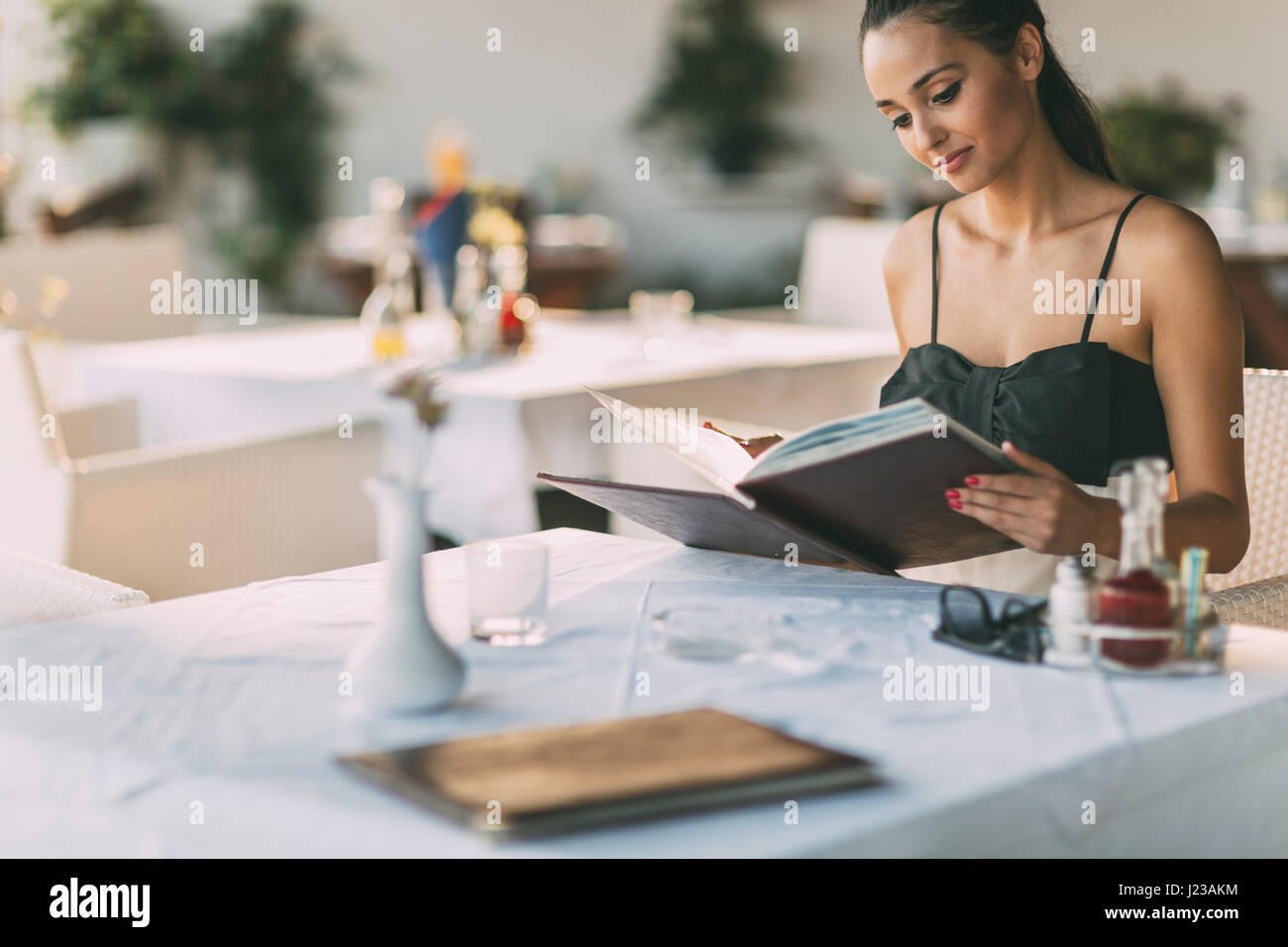 Beautiful woman ordering from menu in restaurant Stock Photo - Alamy