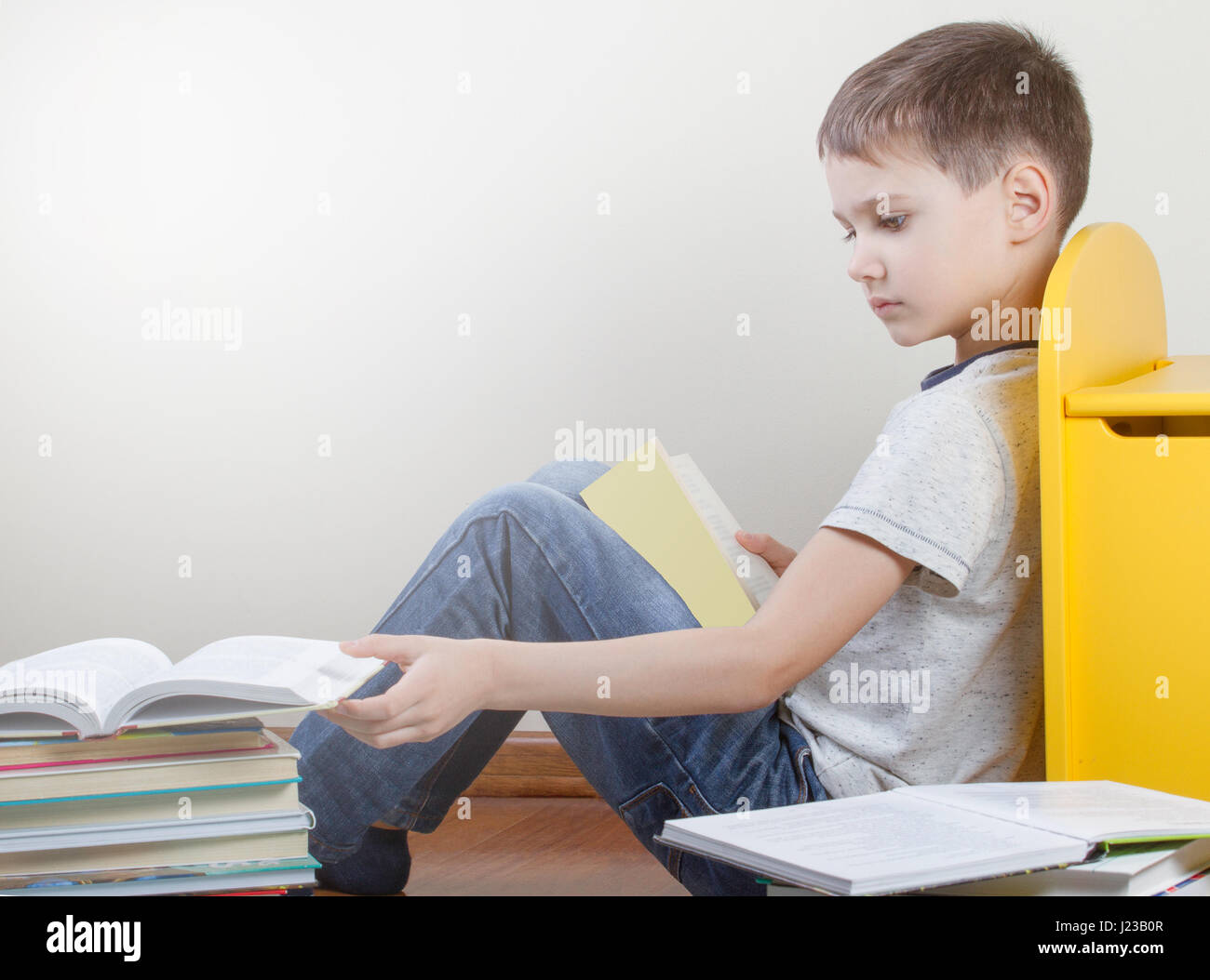 Boy reading books at home Stock Photo - Alamy