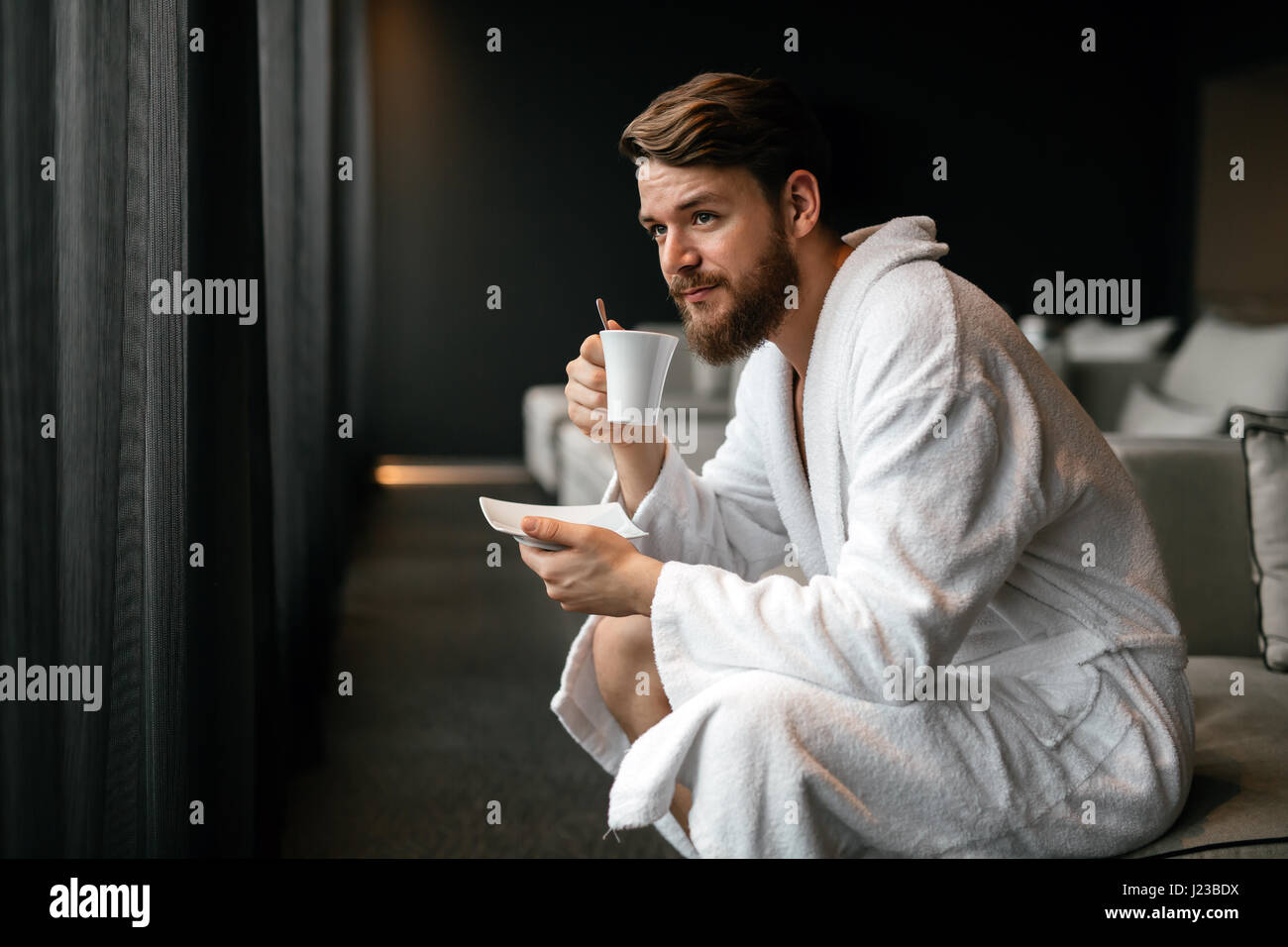 Handsome man drinking tea and relaxing in bathrobe Stock Photo - Alamy