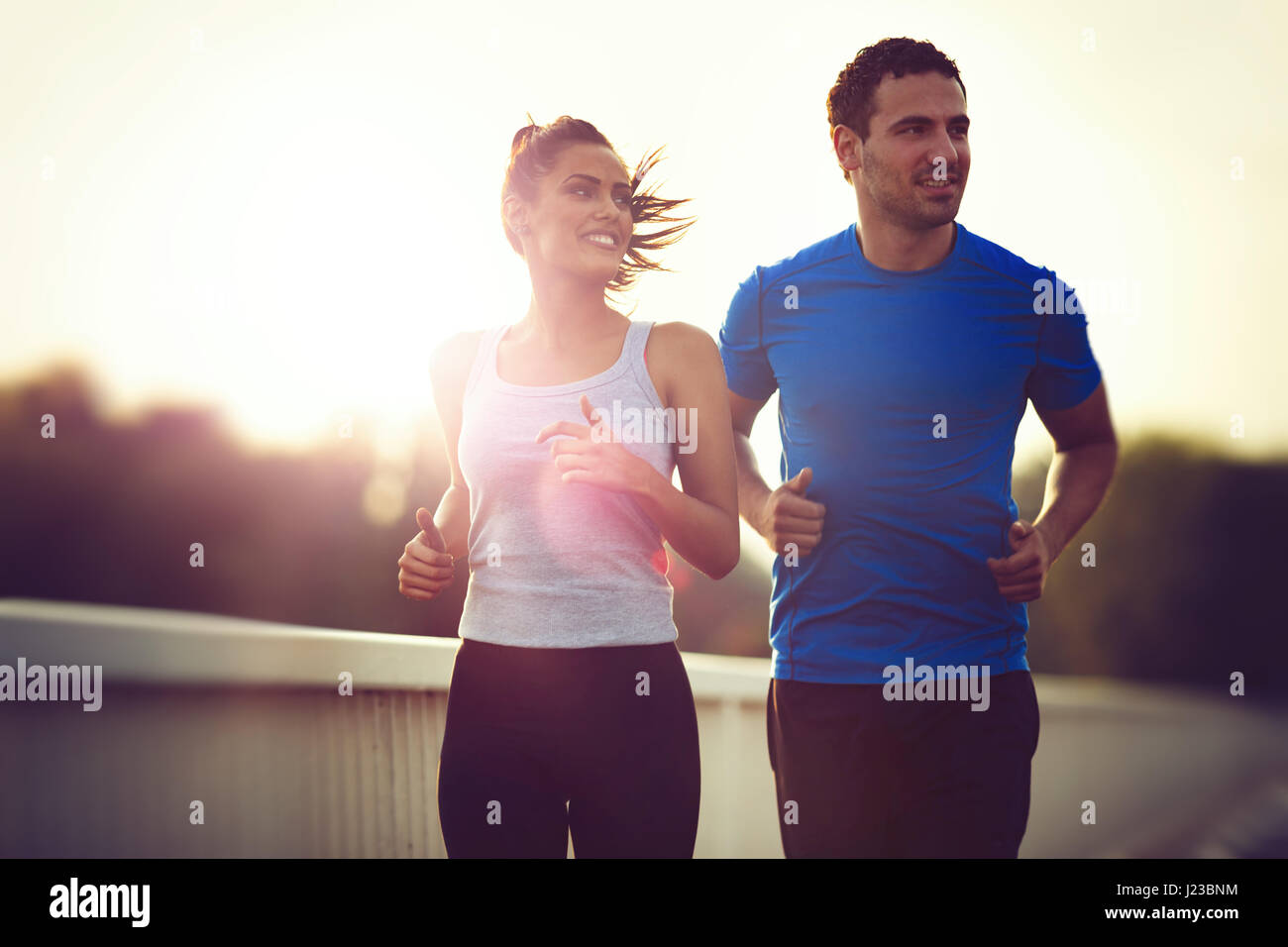 Beautiful sporty couple running and jogging outdoors Stock Photo - Alamy