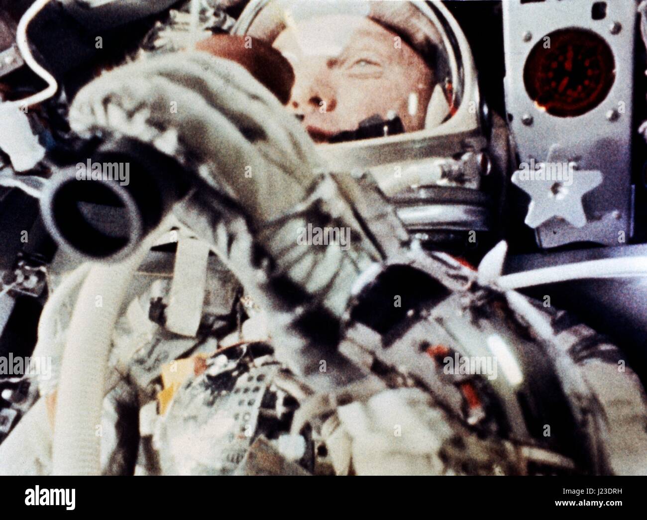 NASA astronaut John Glenn uses binoculars to look at the Earth through ...