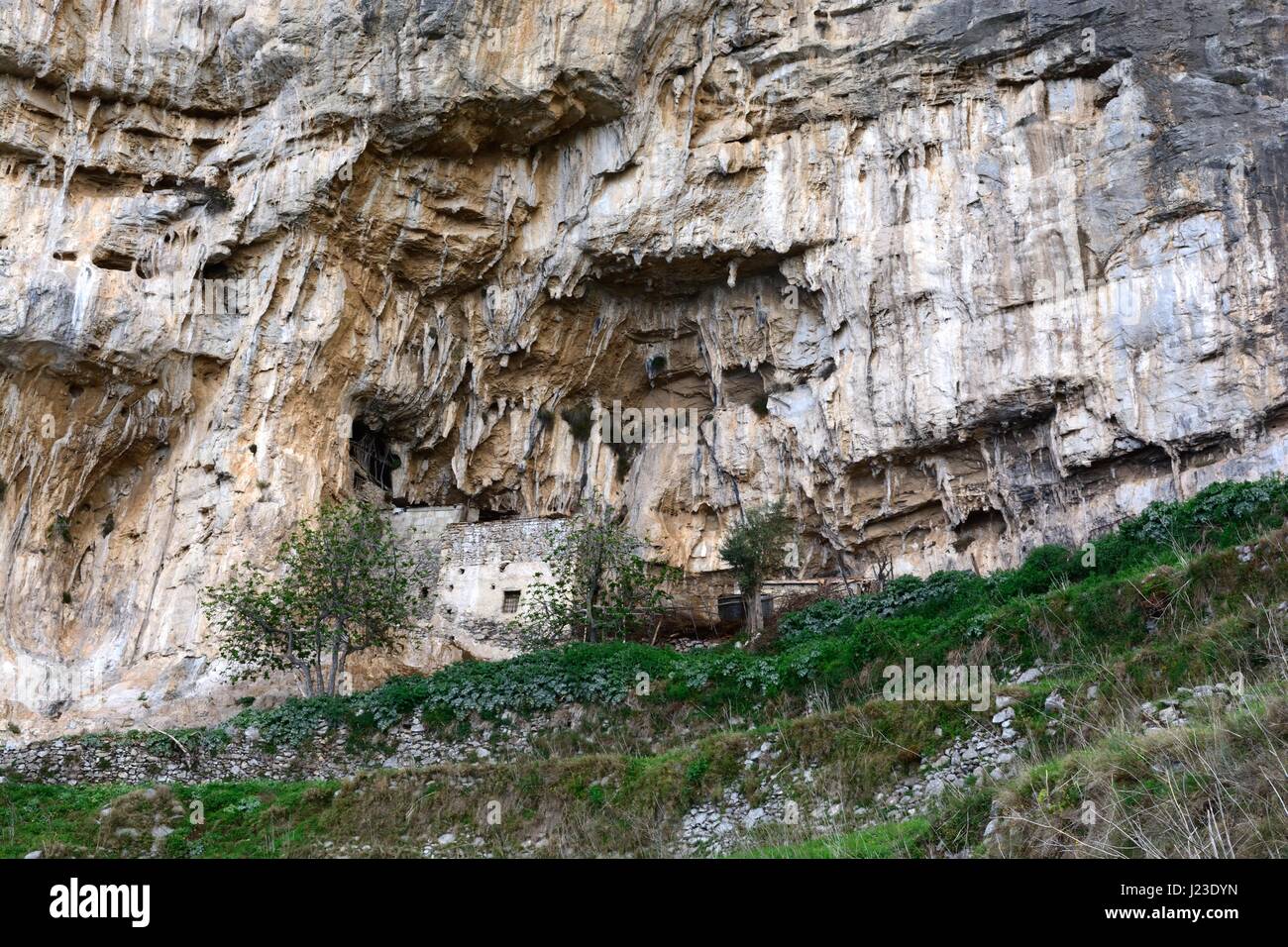Old farm buildings built in limestone cliffs on the Walk of the Gods ...