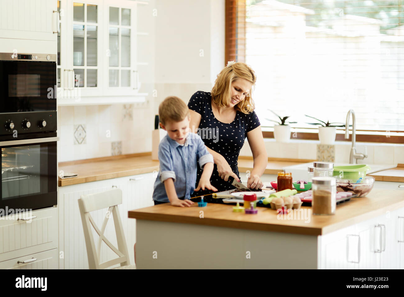 Beautiful child and mother baking in kitchen with love Stock Photo - Alamy