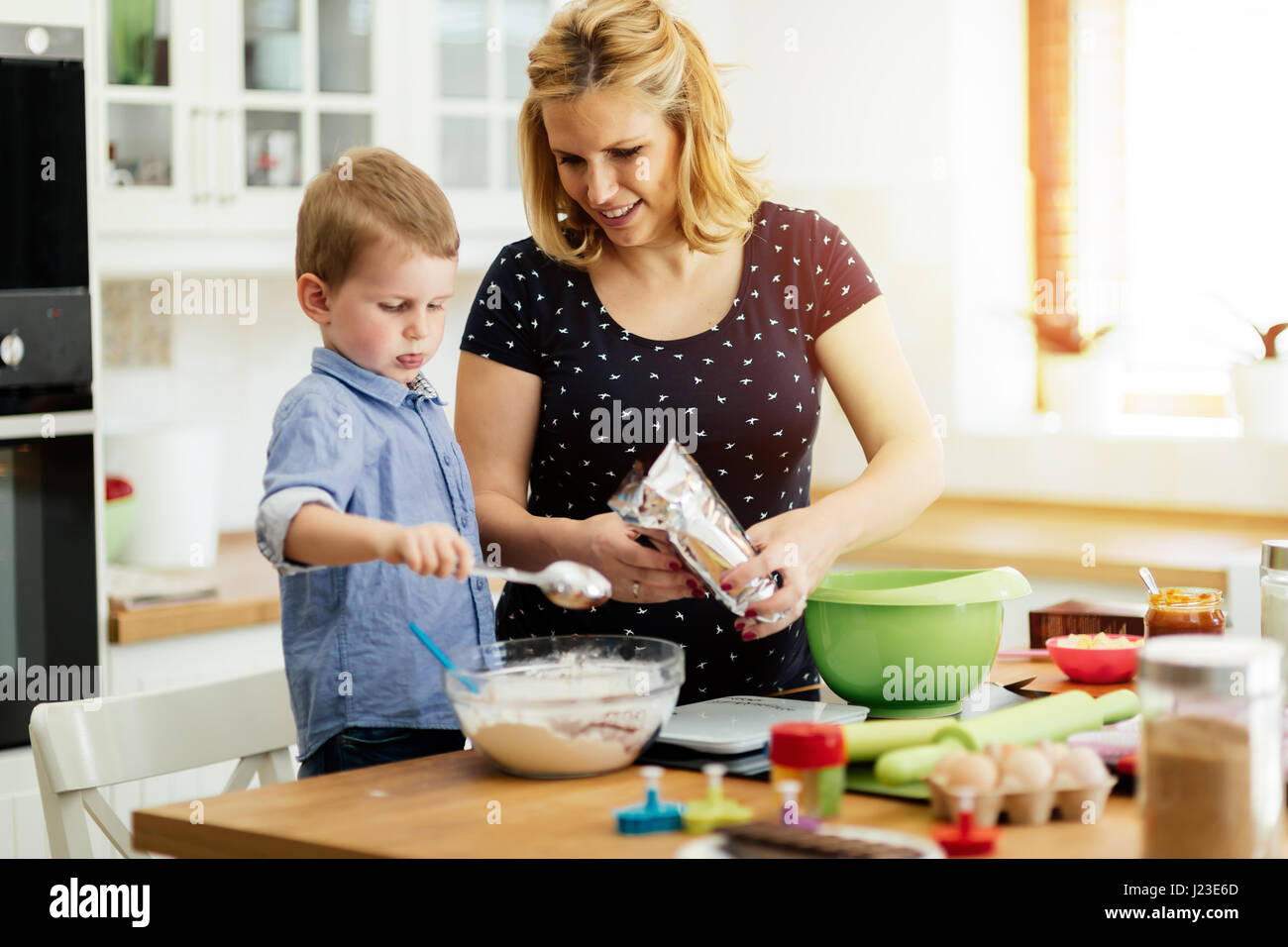 Beautiful child and mother baking in kitchen with love Stock Photo - Alamy