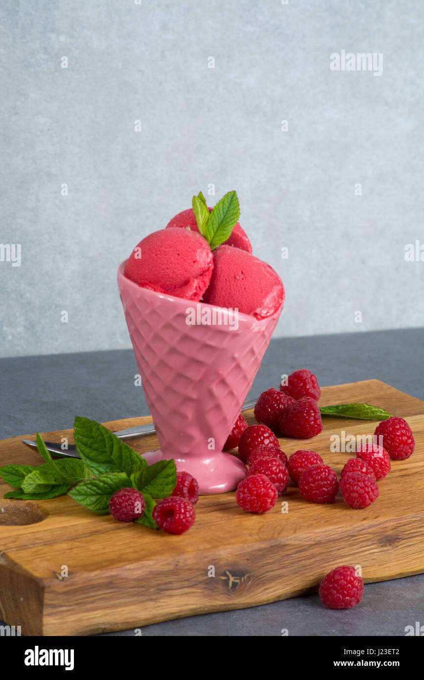 Raspberry ice cream sorbet in pink cone, raspberry, mint leaves copy ...