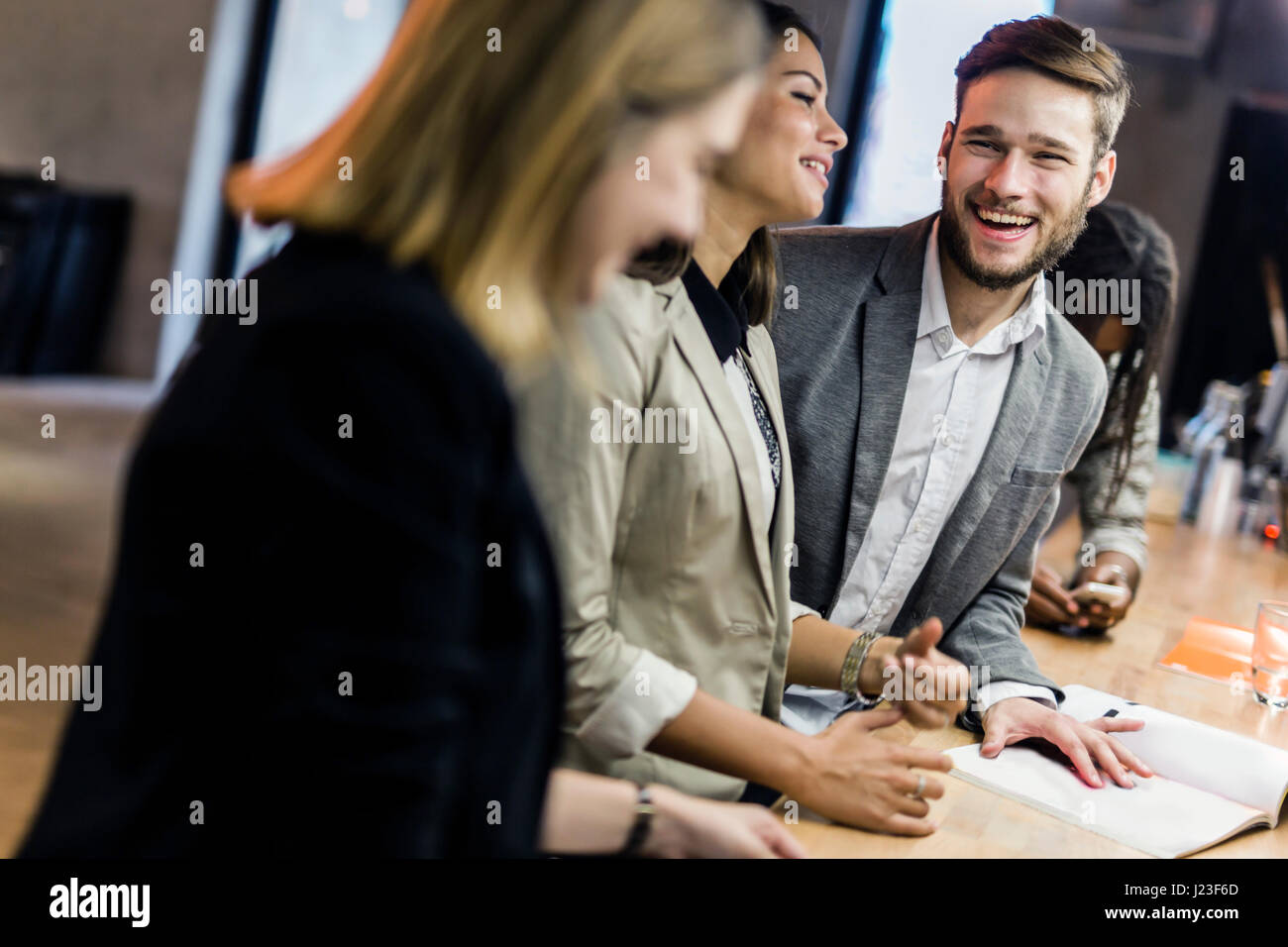 Colleagues having fun in a bar and smiling after work has been finished ...