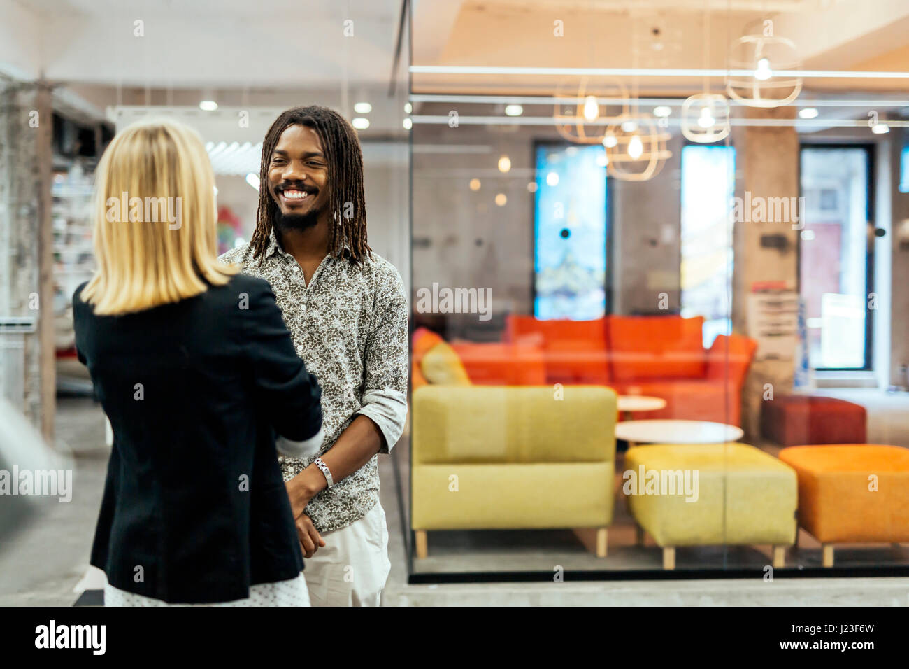 Colleagues smiling and talking in a beautifully designed office Stock ...