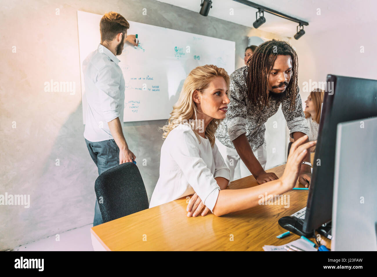 Designer team discussing new ideas and working ona computer Stock Photo ...