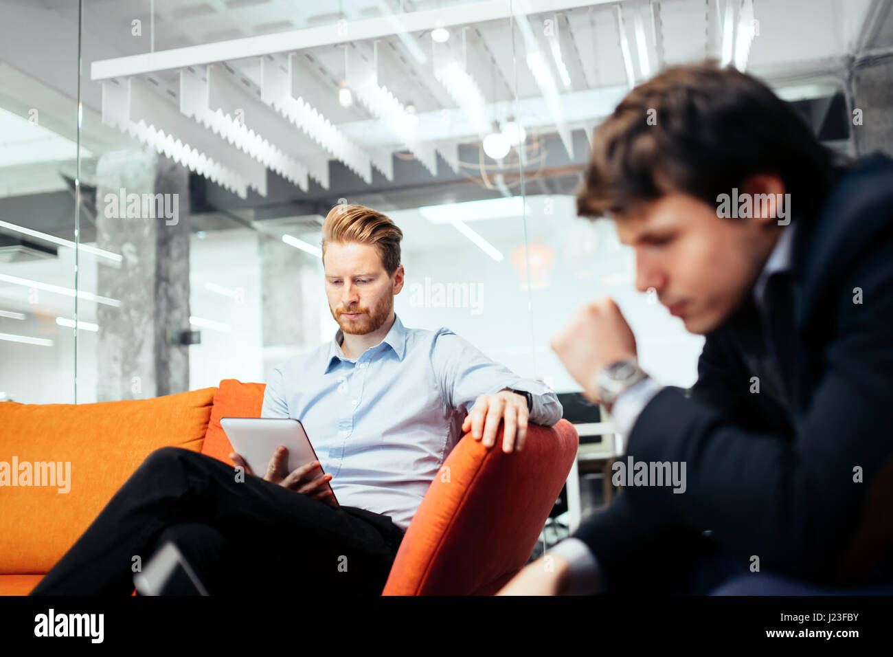 Business people looking at their devices and working Stock Photo - Alamy
