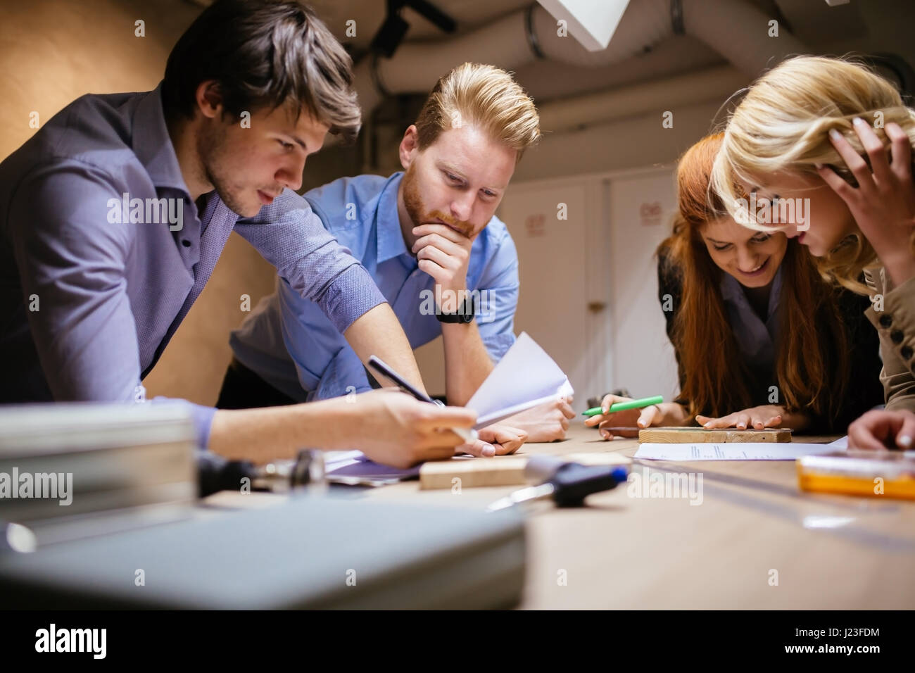Classmates working on a project together and cooperating Stock Photo ...