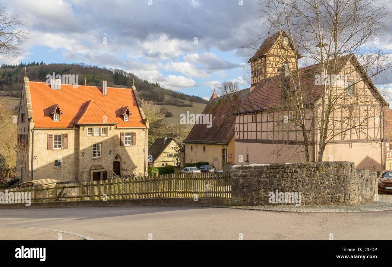 idyllic scenery with historic church and house at evening time in ...