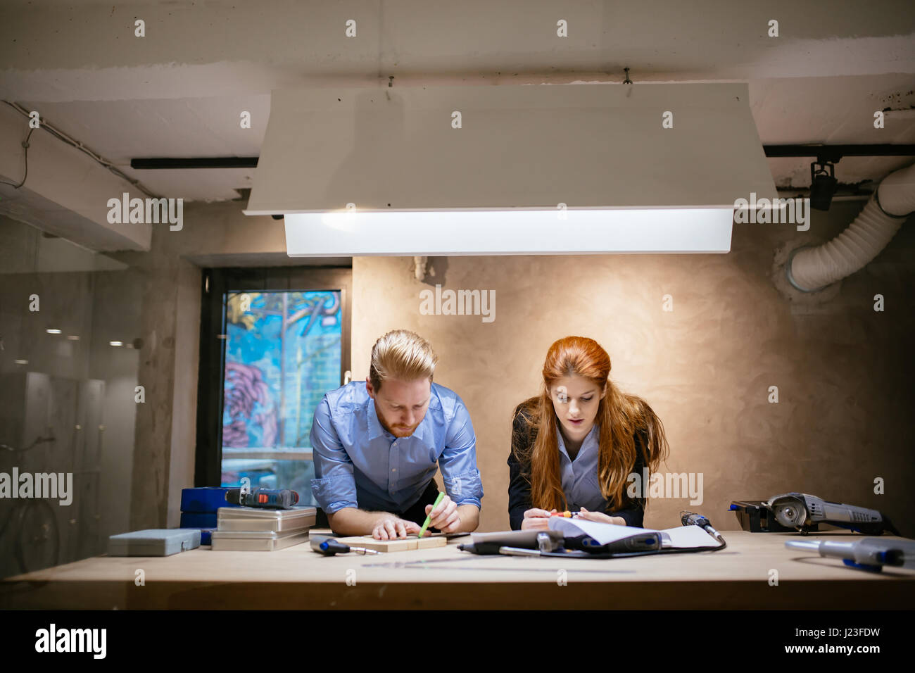 People working in modern beautiful workshop with professional equipment ...