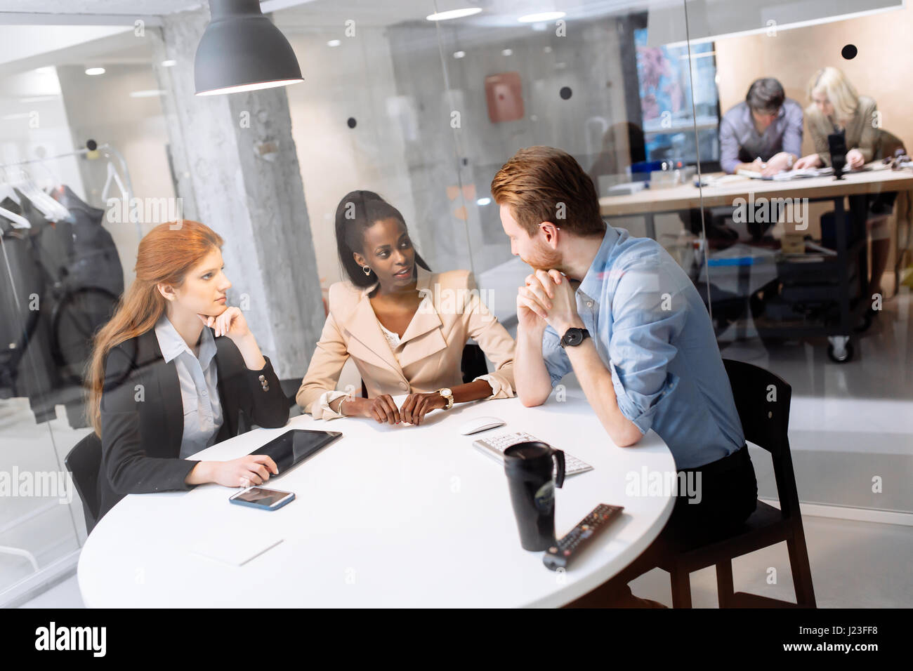 Group people sitting round table hi-res stock photography and images ...