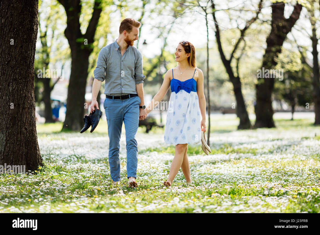 Couple enjoying romantic walk in nature barefoot Stock Photo - Alamy