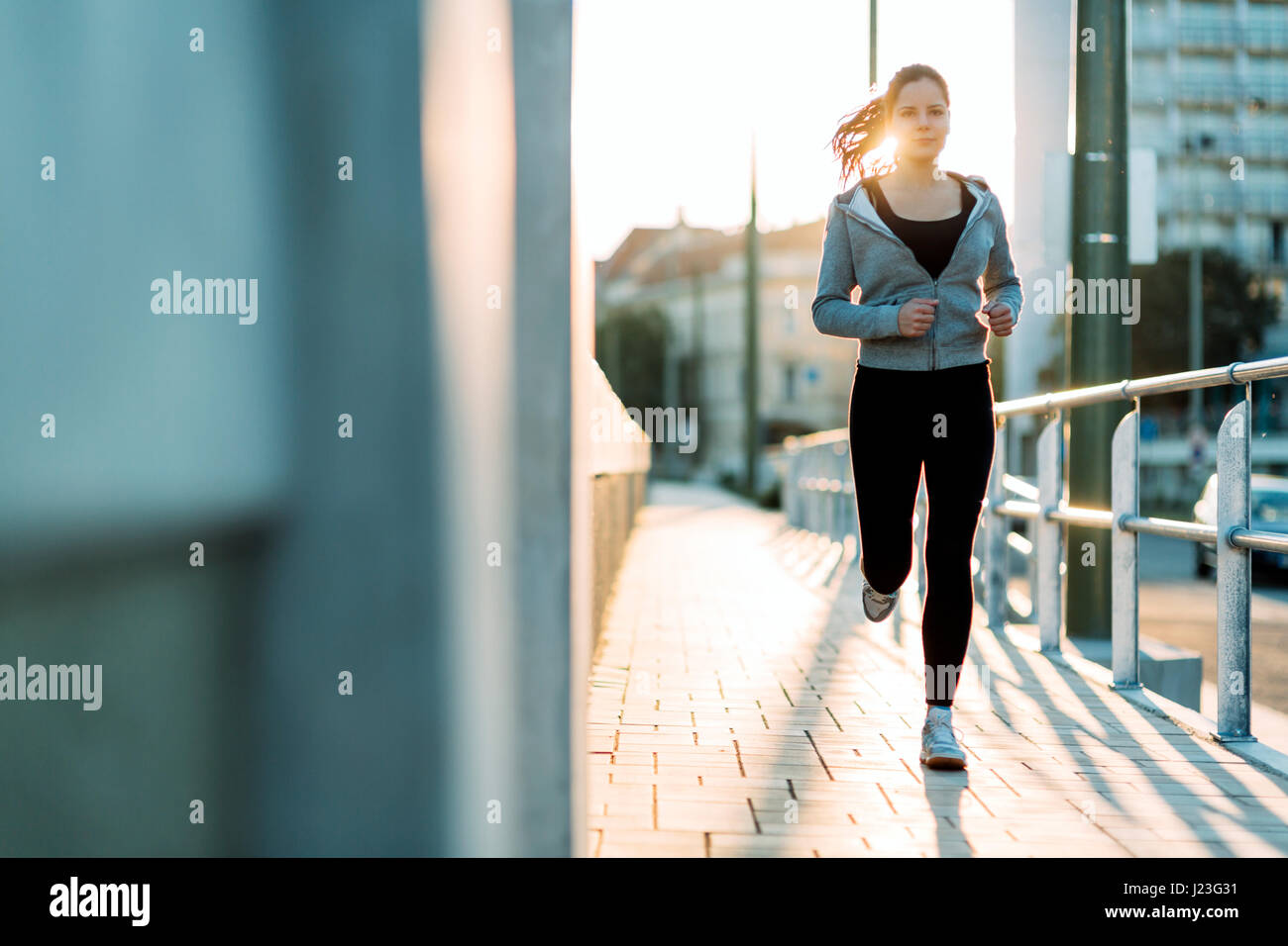 Sporty woman jogging in city to keep her body and soul in shape Stock ...