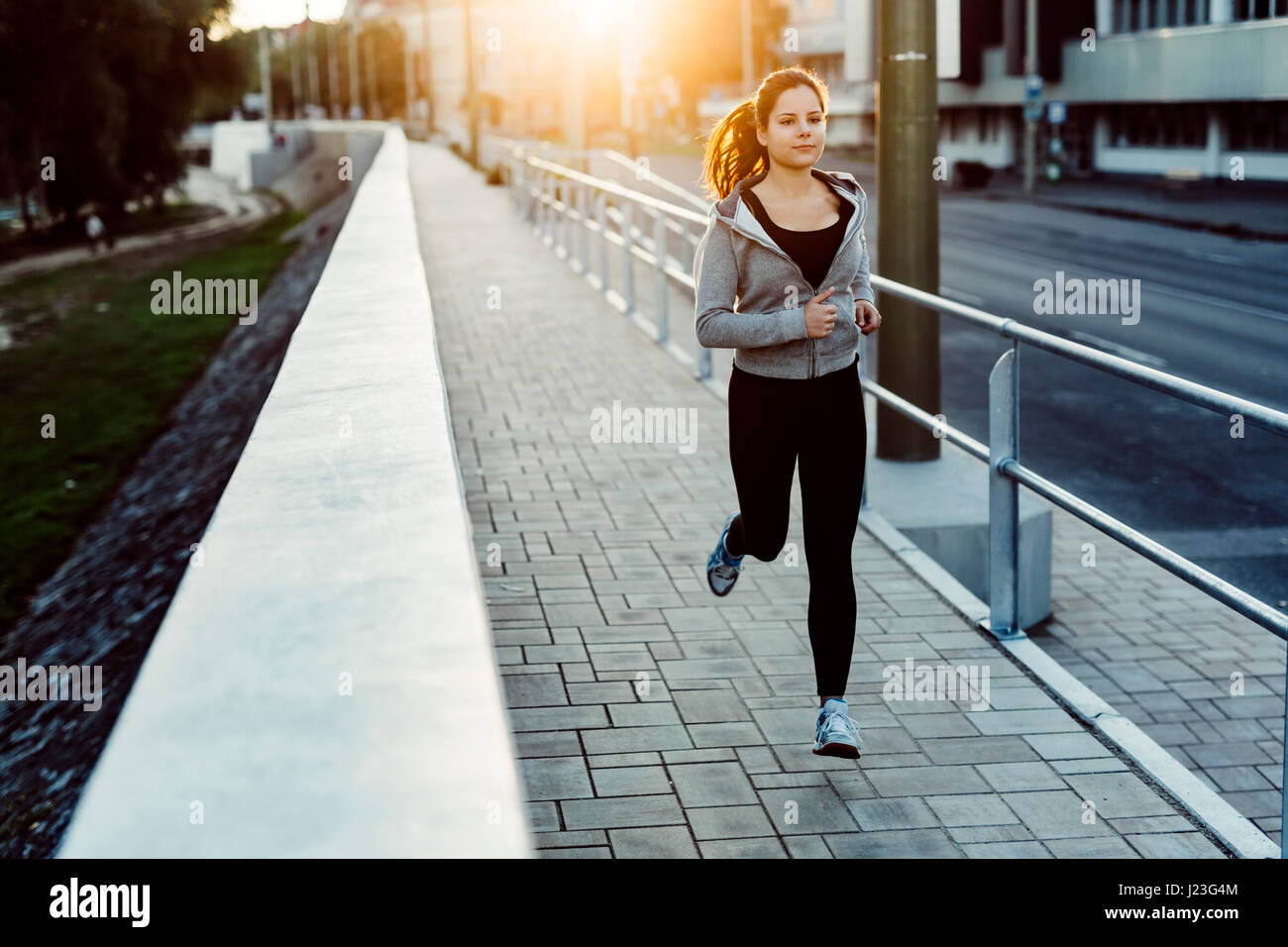 Beautiful female jogging in city and keeping her body in shape Stock ...