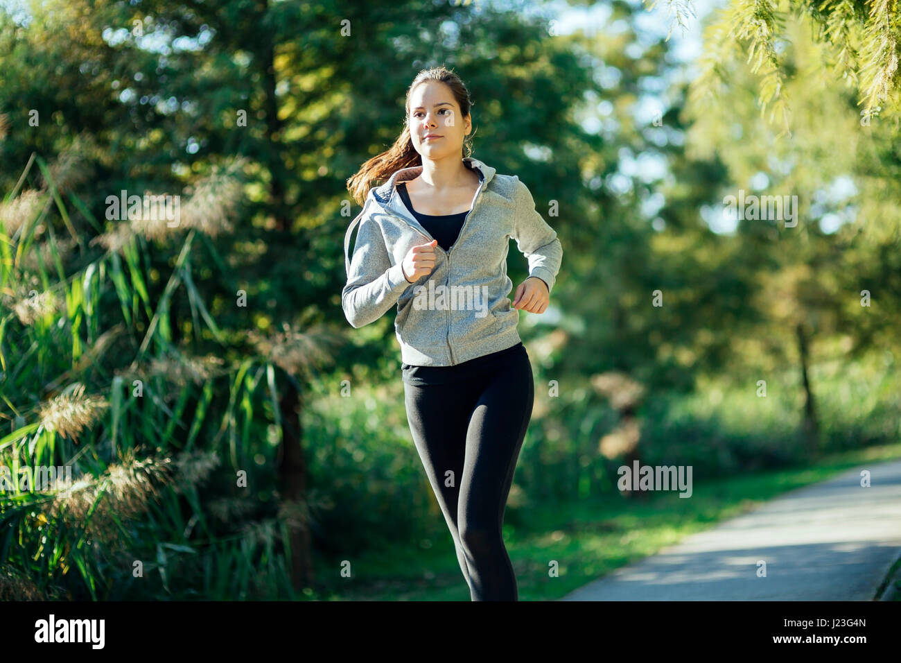 Woman running in park to keep herself in shape Stock Photo - Alamy