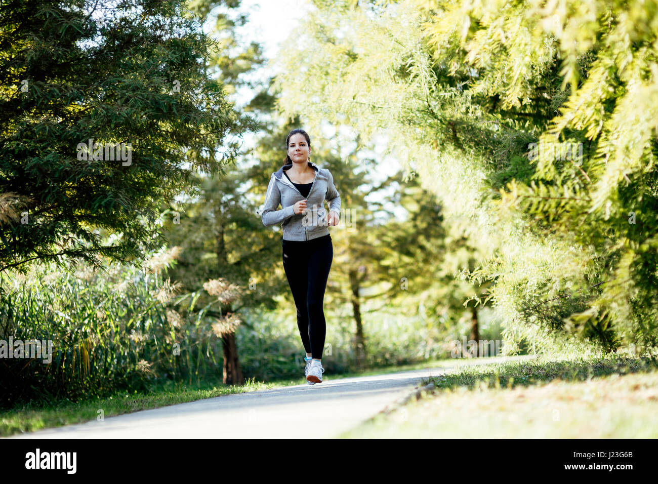 Fit beautiful woman jogging in park and staying healthy Stock Photo - Alamy