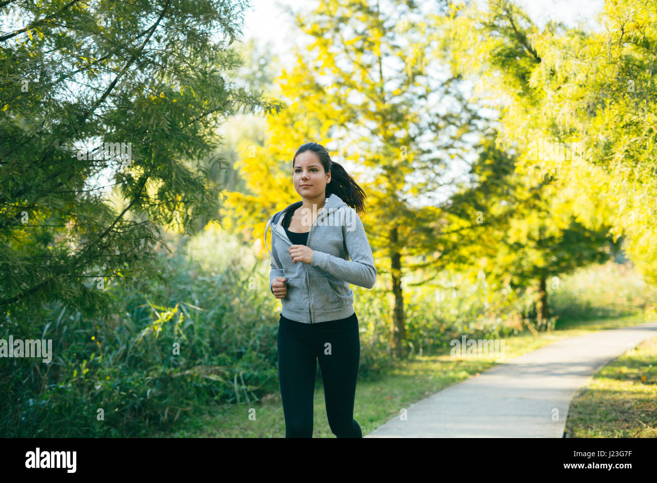 Fit beautiful woman jogging in park and staying healthy Stock Photo - Alamy