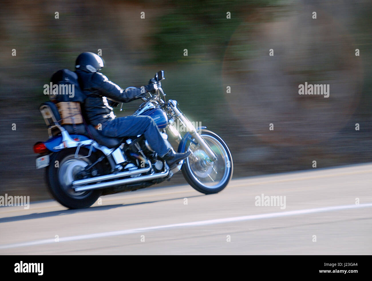 Riding a Harley Davidson motorcycle into the setting sun Stock Photo ...