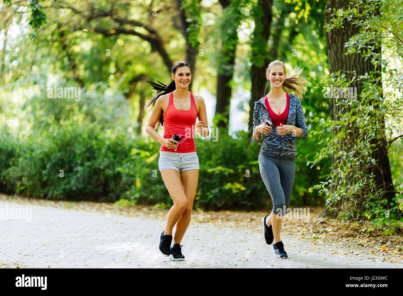 Beautiful sporty women jogging in park Stock Photo - Alamy