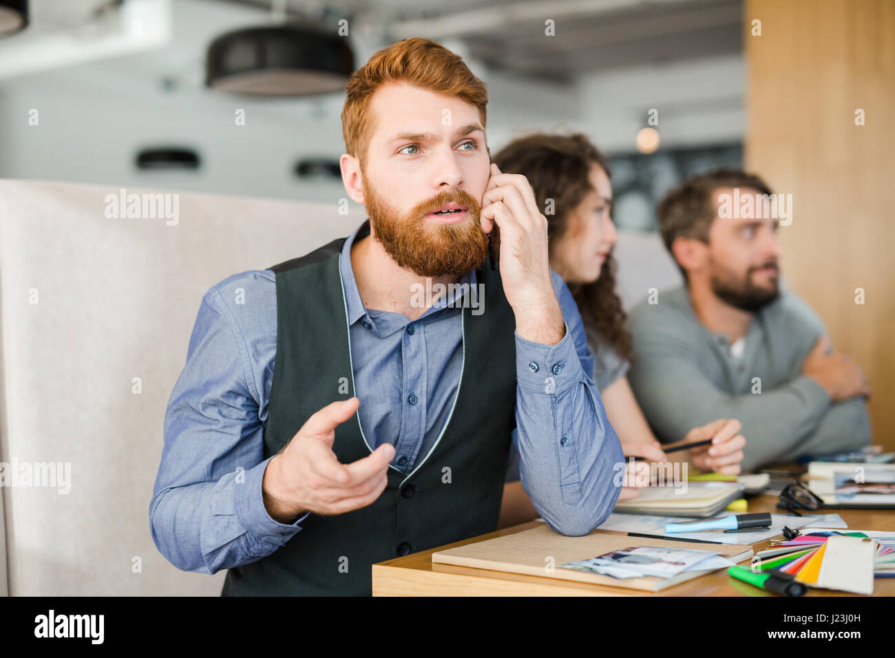 Business leader talking on smartphone by workplace Stock Photo - Alamy