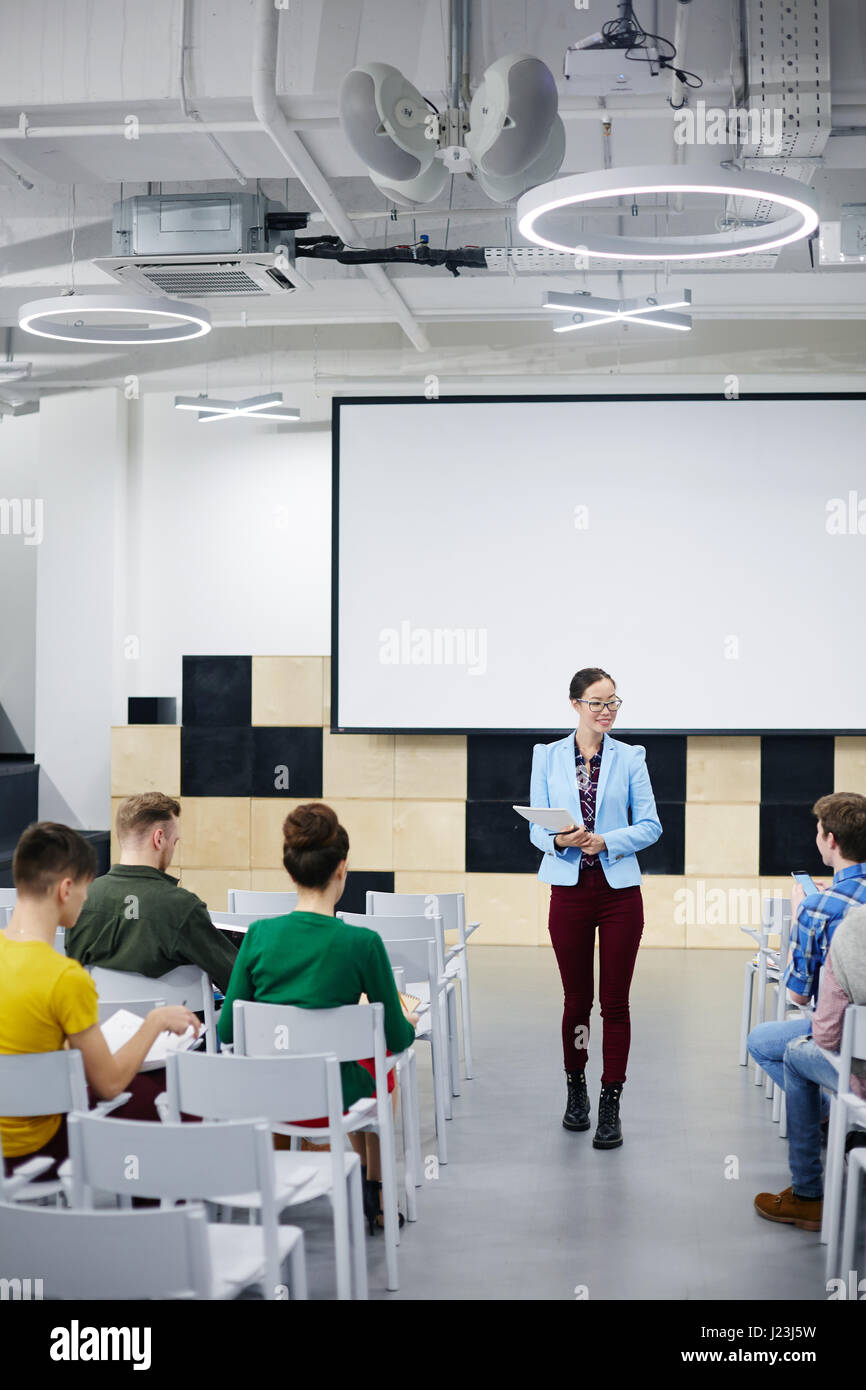 Young teacher making speech in front of audience in lecture hall Stock ...